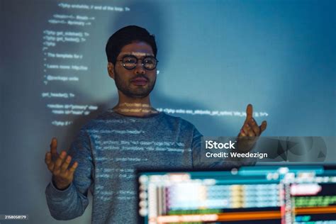 Indian Man Programmer Standing In Front Of A Screen With Code Projected