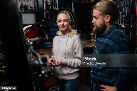 쾌활한 여성 고객과 소통하는 전문 수리공 남성의 초상화 수리점에서 진단 중에 감지된 자전거의 문제 2명에 대한 스톡 사진 및 기타 이미지 Istock