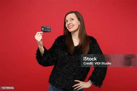 검은 모피 스웨터 조회 신용 은행 카드 스튜디오에서 밝은 빨간색 배경에 고립에서 Thinkful 젊은 여자의 초상화 사람들이 진심으 감정 라이프 스타일 개념 복사 공간을