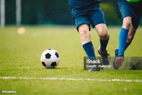 두 명의 성인 축구 선수가 축구공을 차고 달리고 있습니다 경기에 나선 두 젊은 축구 선수의 다리 유럽 축구 유소년 선수들의 활약