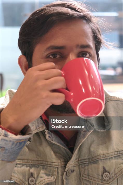 아름 다운 힌두교 인도 남자의 이미지 호텔 레스토랑에서 미소를 지으 면 서 아침 식사와 마시는 레드 머그잔 커피 카푸치노 차 핫 초콜릿 옅은 파란색 데님 재킷 갈색 머리에