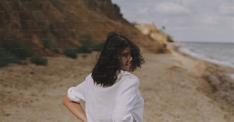 햇볕이 잘 드는 해변에서 달리는 흰 셔츠를 입은 보헤미안 소녀 뒷모습 수영복과 셔츠를 입고 해변에서 휴식을 취하는 평온한 세련된 여성 여름 방학 라이프 스타일 정통