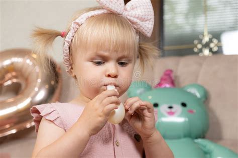 Two Year Old Blonde Girl Eating Birthday Cake On Her Birthday Stock