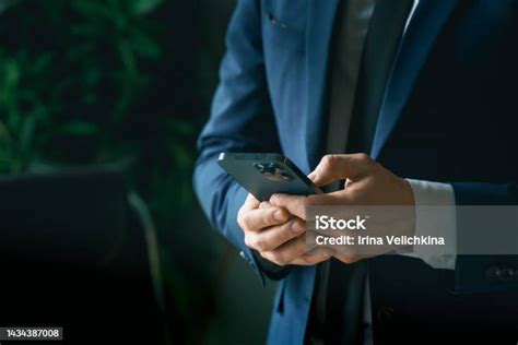 손에 휴대 전화를 가진 정장을 입은 사업가 소셜 넷을 사용하여 메시지를 입력하는 남자 뉴스 확인 비즈니스 미팅 만들기 현대적인 사무실 일반 관리자 Ceo 파트너에게 전화하기