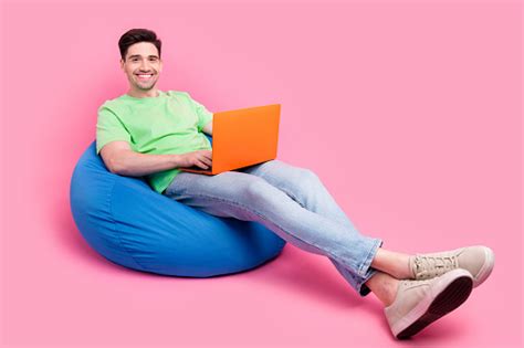 원격 근무 사업가의 전체 길이 사진 부드러운 콩 주머니 공동 작업 영역 쓰기 계획 노트북 절연 통하고 분홍색 배경 컴퓨터