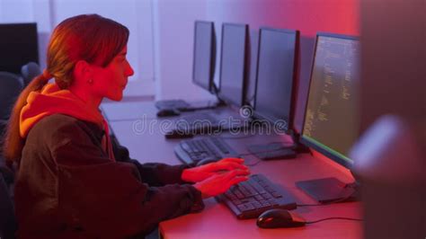 Beautiful Young Female Programmer Working In Office Pink Light In A