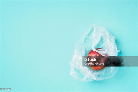 파란색 배경에 비닐 봉지에 나쁜 빨간 사과를 버릇 쓰레기 덤프 썩은 음식 맨 위 보기 공간을 복사합니다 썩은 야채와 과일 개념 폐기물 제로 퇴비 가방에 대한 스톡 사진 및