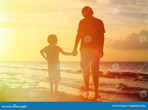 Padre E Figlio Che Si Tengono Per Mano Al Tramonto Fotografia Stock
