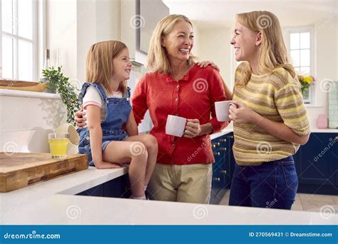 Familia Del Mismo Sexo Con Dos Madres Maduras Y Su Hija Sentadas En La Cocina Hablando Juntas