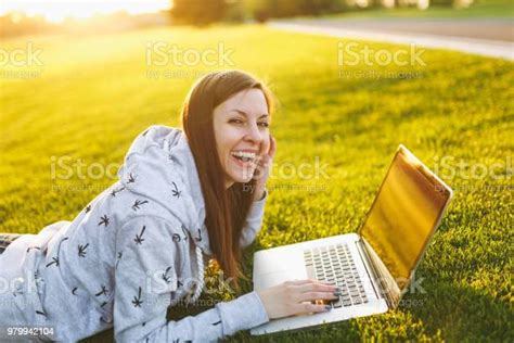 영 캐주얼 옷에 여성 학생 스마트 여자 녹색 햇빛 잔디 야외에 도시 공원에서 노트북 Pc 컴퓨터에 작업 잔디 그라운드에 누워 모바일 사무실입니다 프리랜서 비즈니스 개념입니다