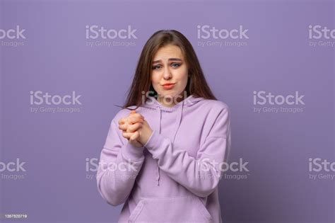 소녀는 턱 아래 손을 잡고 아름다운 무언가를 존경하고 애정과 부드러움으로 보이며 감동한 매혹적인 표정으로 한숨을 쉬고 보라색