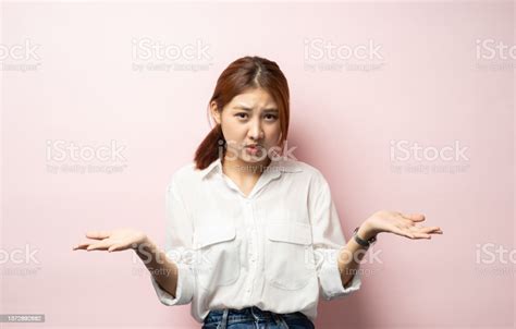 죄송합니다 내 실수 여자는 어깨를 으쓱하고 어색한 미소를 지으며 죄책감을 느끼고 사과하고 카메라를 아늑하게 바라보며 분홍색 배경 위에 서 있었다 20 29세에 대한 스톡