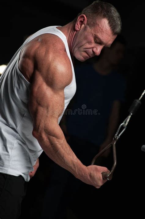 Hombre Maduro Fuerte Con El Cuerpo Del Alivio Que Presenta En Gimnasio Imagen De Archivo