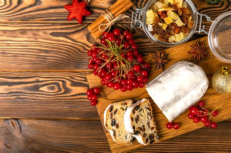 크리스마스 슈톨렌 전나무 가지가 있는 갈색 나무 테이블에 있는 전통적인 독일 빵 가루 설탕을 뿌린 반죽 견과류 마지팬으로 만든