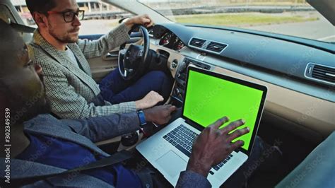 African Entrepreneur Inside Auto Using Mock Up Green Chrome Key Laptop