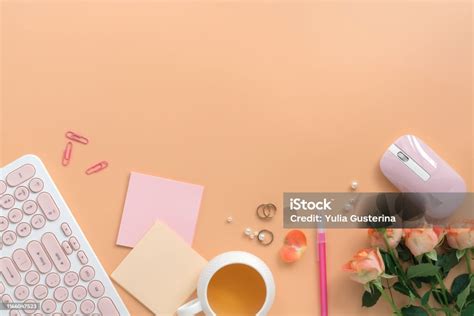 플랫 평신도 여성 작업 공간 키보드 마우스 차 한 잔 장미 꽃 보석 및 문구는 분홍색 파스텔 배경에 여성스러운 오피스 테이블