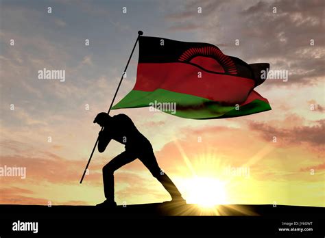 malawi flag being pushed into the ground by a male silhouette 3d
