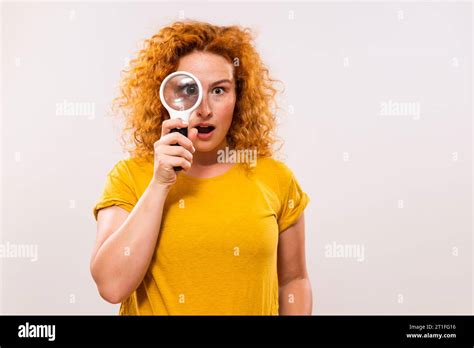 Portrait Of Surprised Ginger Woman Looking Through Loupe Stock Photo