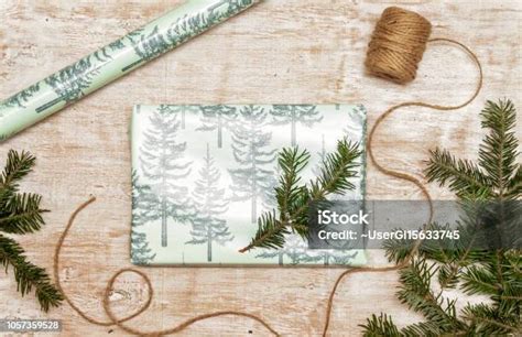 새 해와 크리스마스 선물 가문비나무 꼬기 나무 배경에 로프 녹색 분홍색 종이 포장 하는 과정입니다 보기 복사 공간 평평 하다