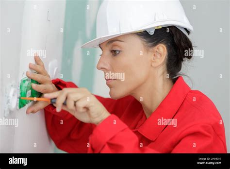 Female Electrician Testing A Wall Socket Stock Photo Alamy