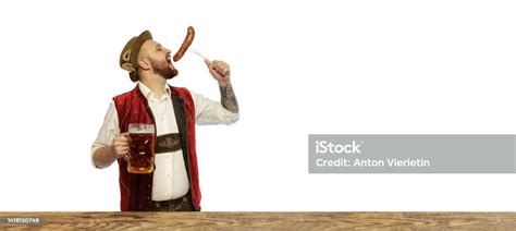 전통적인 바이에른 또는 독일 옷을 입은 청년이 소시지를 먹고 흰색 배경에 고립 된 맥주를 마시는 초상화 소시지에 대한 스톡 사진 및 기타 이미지 Istock