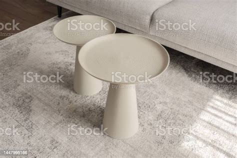 밝은 회색 카펫과 다양한 크기의 둥근 질감의 금속 커피 테이블 2개가 있는 현대적인 거실 인테리어 0명에 대한 스톡 사진 및