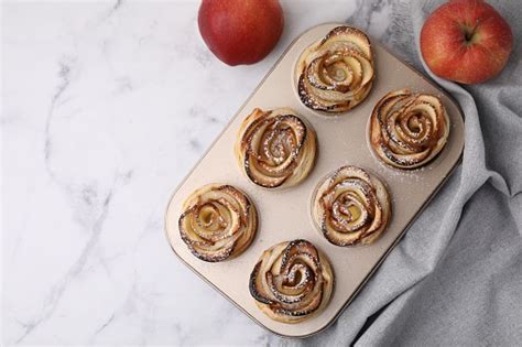 하얀 대리석 테이블 위에 갓 구운 사과 장미와 신선한 과일이 놓여 있고 글을 넣을 수 있는 공간이 평평하게 놓여 있습니다 퍼프 페이스트리 0명에 대한 스톡 사진 및 기타