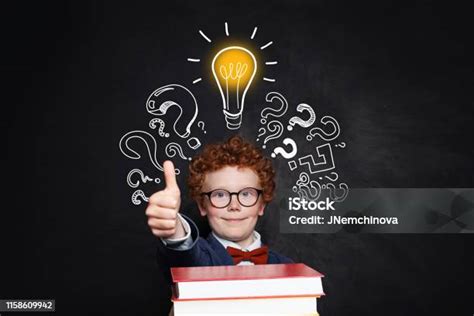 책을 들고 칠판 배경에 전구에 대한 엄지 손가락을 보여주는 스마트 아이 브레인스토밍 및 아이디어 컨셉 개념에 대한 스톡 사진 및 기타 이미지 Istock