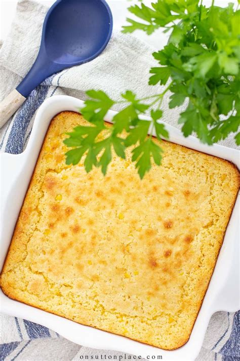 A Casserole Dish With Parsley On Top And Spoons Next To It