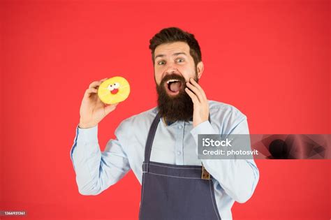 설탕에 대한 진정한 사실 안 돼요 힙스터 수염 베이커는 붉은 배경에 유리 도넛을 보유하고 있습니다 카페와 베이커리 컨셉 베이커에서 달콤한 도넛 남자 수염 베이커 요리 에