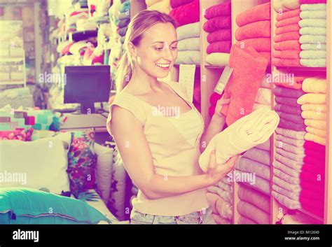 Young Smiling Woman Buying Soft Towels In Home Textile Store Stock