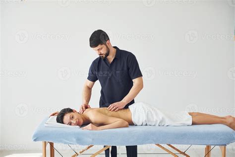 Young Woman Is Lying Down When Man Doing Massage Of Her Body At Spa