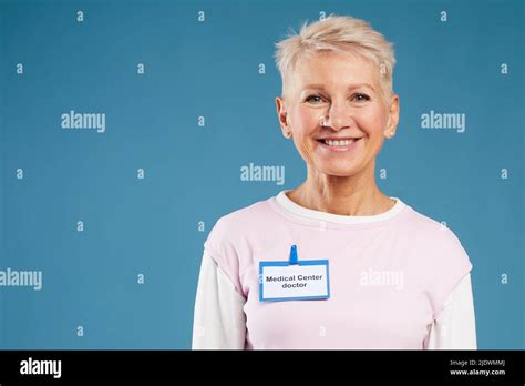 Cheerful Attractive Female Worker Of Healthcare Center Wearing Badge