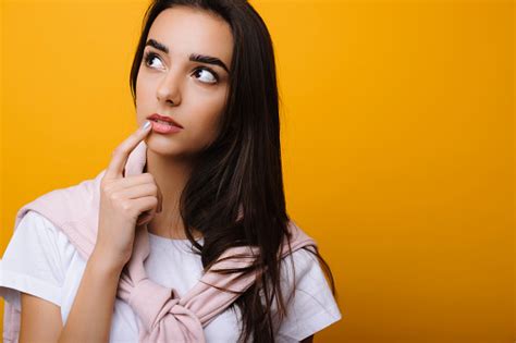 뭔가에 대해 생각 하거나 노란 벽에 그녀의 입술에 손가락으로 기억 하려고 하는 아름 다운 백인 여자의 초상화를 닫습니다 T 셔츠에 대한 스톡 사진 및 기타 이미지 Istock