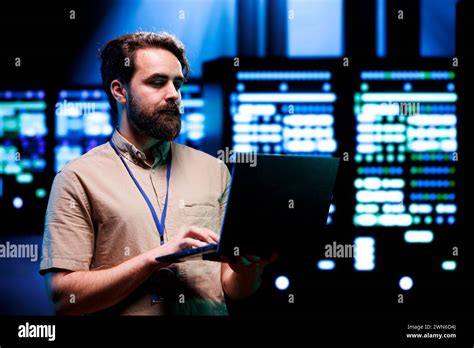 Meticulous Engineer Inspecting Operational Server Rows In Computer Network Security Data Center
