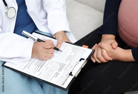 의사가 만삭의 임산부 환자의 진료기록부를 작성하는 모습 ภาพถ่ายสต็อก Adobe Stock