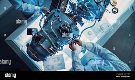 Two Professional Jet Engine Researchers Discussing Work Using Laptop Computer And Checking