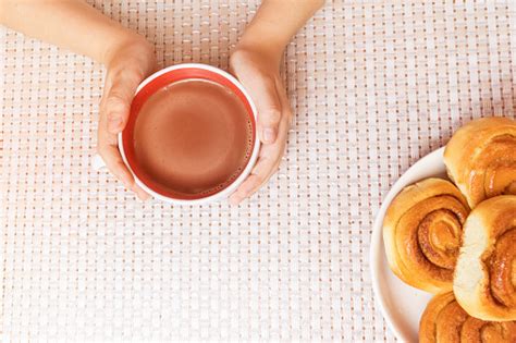 어린이의 손에는 코코아 한 잔을 들고 있으며 인근 테이블에는 빵 한 접시가 있습니다 위에서 볼 수 있습니다 공간을 복사합니다 빵집에 대한 스톡 사진 및 기타 이미지 Istock