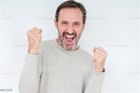 고립 된 배경을 통해 우아한 노인은 매우 행복하고 성공을 위해 미소와 비명을 지르는 팔을 들고 우승자 제스처를하고 흥분 축 하 개념입니다 긍정적인 감정 표현에 대한 스톡