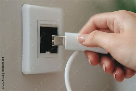 A Hand Plugging A USB Cable Into A Wall Socket Demonstrating Modern Connectivity And The