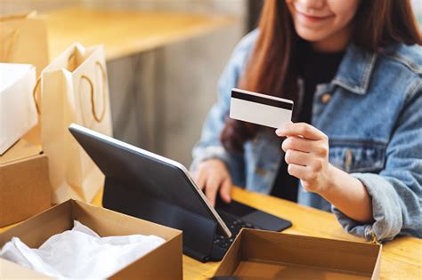 테이블에 우편 소포 상자와 쇼핑 가방온라인 쇼핑을위한 태블릿 Pc와 신용 카드를 사용하는 젊은 아시아 여성 가방에 대한 스톡 사진 및 기타 이미지 Istock