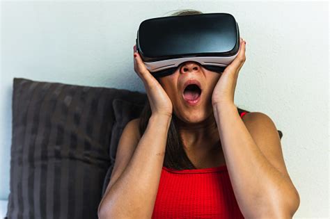 겁에 질린 갈색 머리 여자는 입을 벌리고 가상 현실 고글을 실험 한 후 그녀의 얼굴에 손을 잡았습니다 증강 현실을 바라보는 그녀의 방에서 어린 소녀의 정면 이미지 3차원