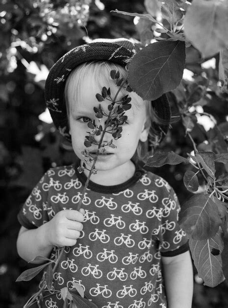 Premium Photo Portrait Of Boy Holding Twig Against Plants