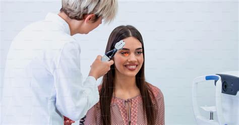 실험실에서 안과 장비로 눈 건강 체크 특별한 장치를 사용하여 젊은 예쁜 소녀의 시력을 향상 시키려고합니다 눈 건강을 위한 의료 기기 작업 사진 Unsplash의 사람 이미지