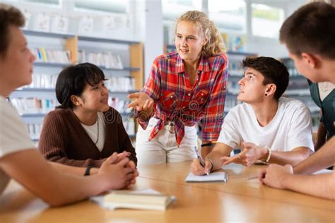Grupo De Alunos Da Biblioteca Da Escola Discutindo Algo Foto De Stock