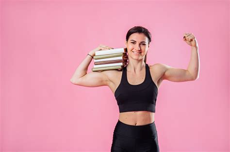 Gadis Cantik Menarik Berotot Memegang Set Buku Berat Di Satu Sisi Dan