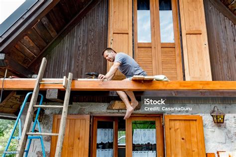 나무 기둥에 새로운 판자를 고정 하는 휴일 집 발코니를 개조 하는 남자 Diy에 대한 스톡 사진 및 기타 이미지 Diy 건물 외관 공예 Istock