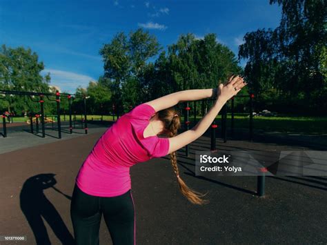 분홍색 운동복 여름 아침에 거리 운동 장소에서 연습을 하 고 있는 소녀 코어 쪽 워밍업으로 굽어입니다 건강 한 라이프 스타일 스포츠 개념입니다 땋은 머리에 대한 스톡 사진