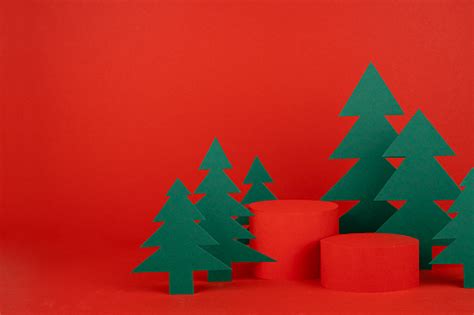두 개의 빨간 실린더 연단 모형 프레젠테이션 화장품 선물 상품 복사 공간을 위한 예술 스타일의 녹색 종이 가문비나무가 있는 축제