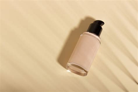 그림자가 있는 배경에 유리 병에 파운데이션 복사 공간이 있는 베이지 색 배경의 얼굴 보정기입니다 복사 공간을 갖춘 패키징 모형 0명에 대한 스톡 사진 및 기타 이미지